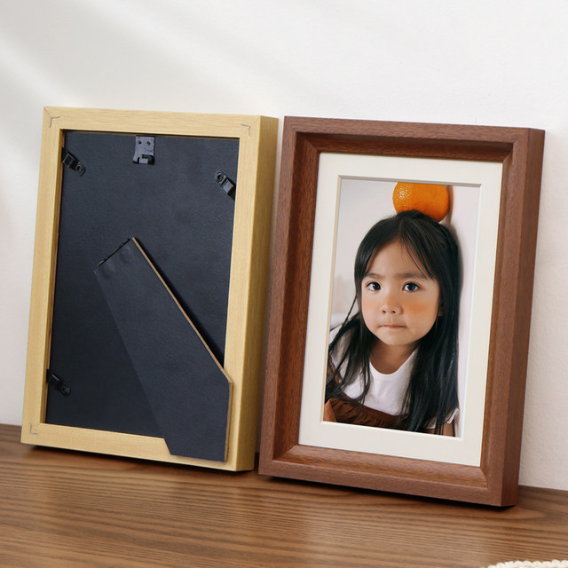 Solid wood photo frame set up on the table and washed photos to make a ...